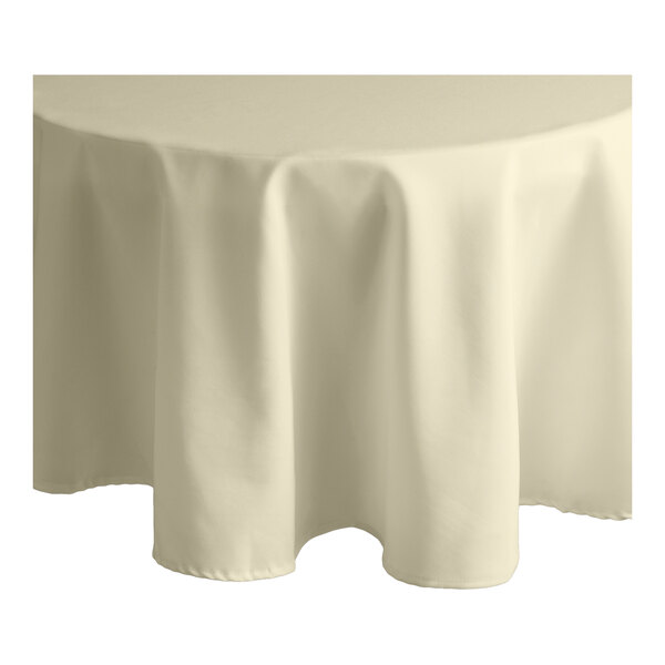Intedge 132" Round Ivory Seamed 100% Polyester Hemmed Cloth Table Cover